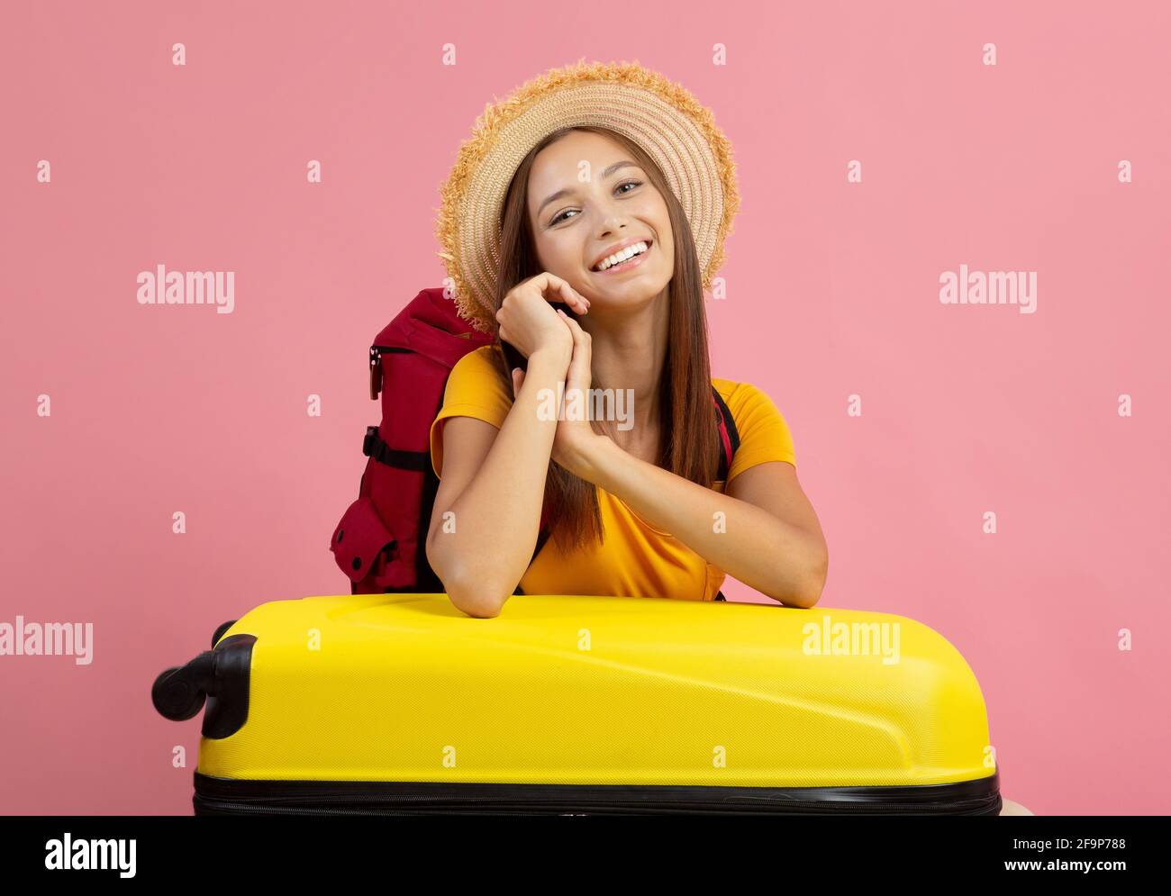 Happy young woman backpacker leaning on suitcase Stock Photo - Alamy