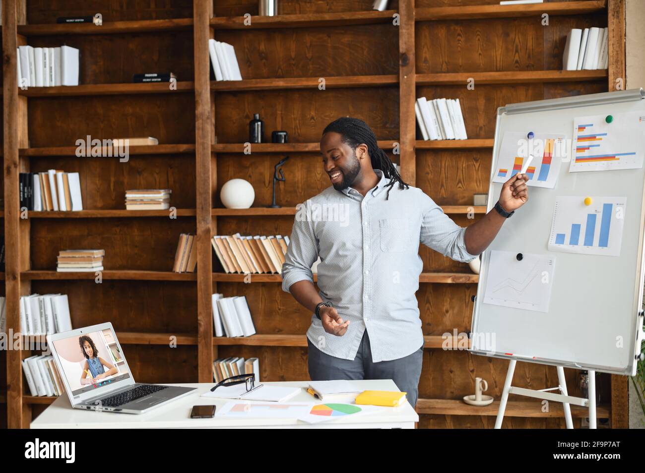 An African-American online teacher, tutor, business coach is holding ...