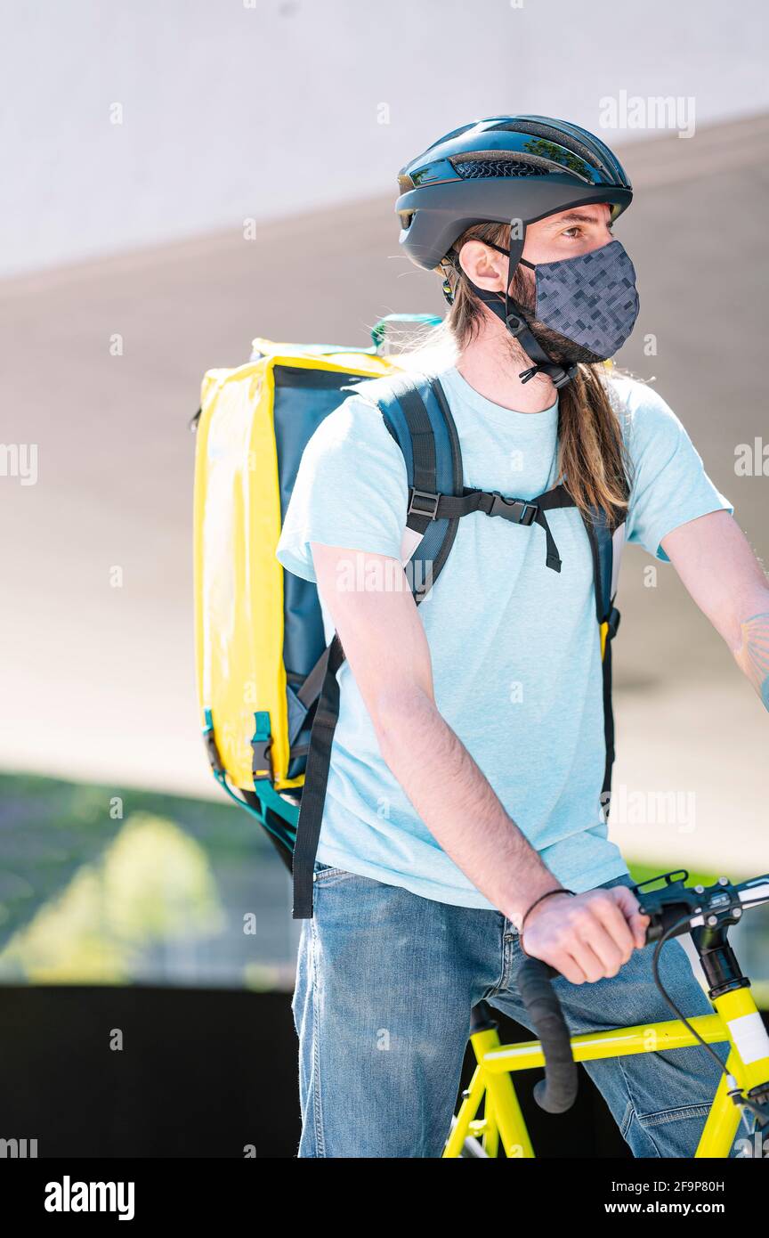 Food delivery service by delivery service. Cyclist with mask for safety ...