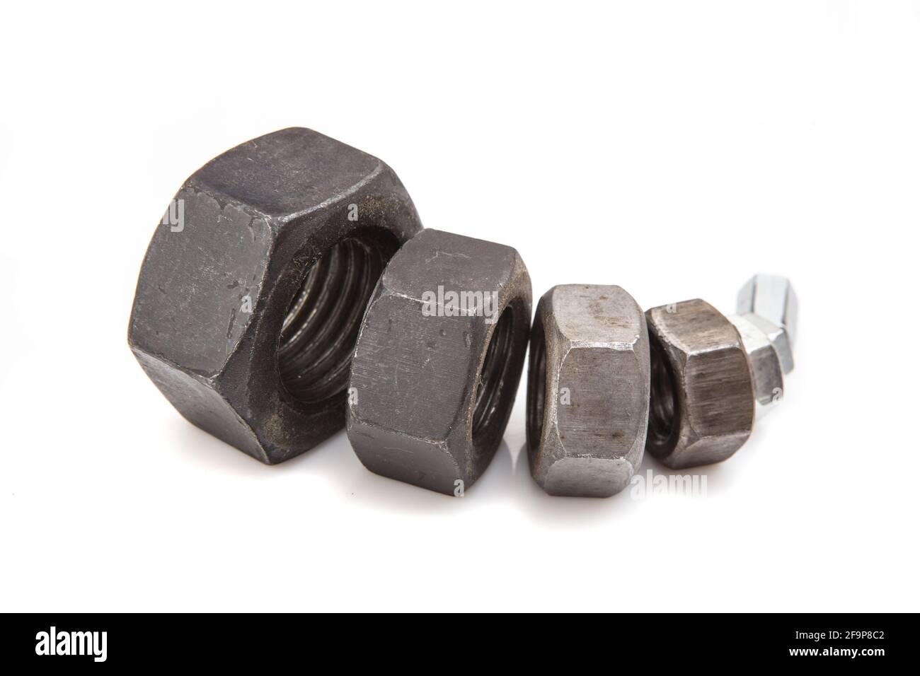 metal hexagon nuts of different sizes on a white background Stock Photo ...