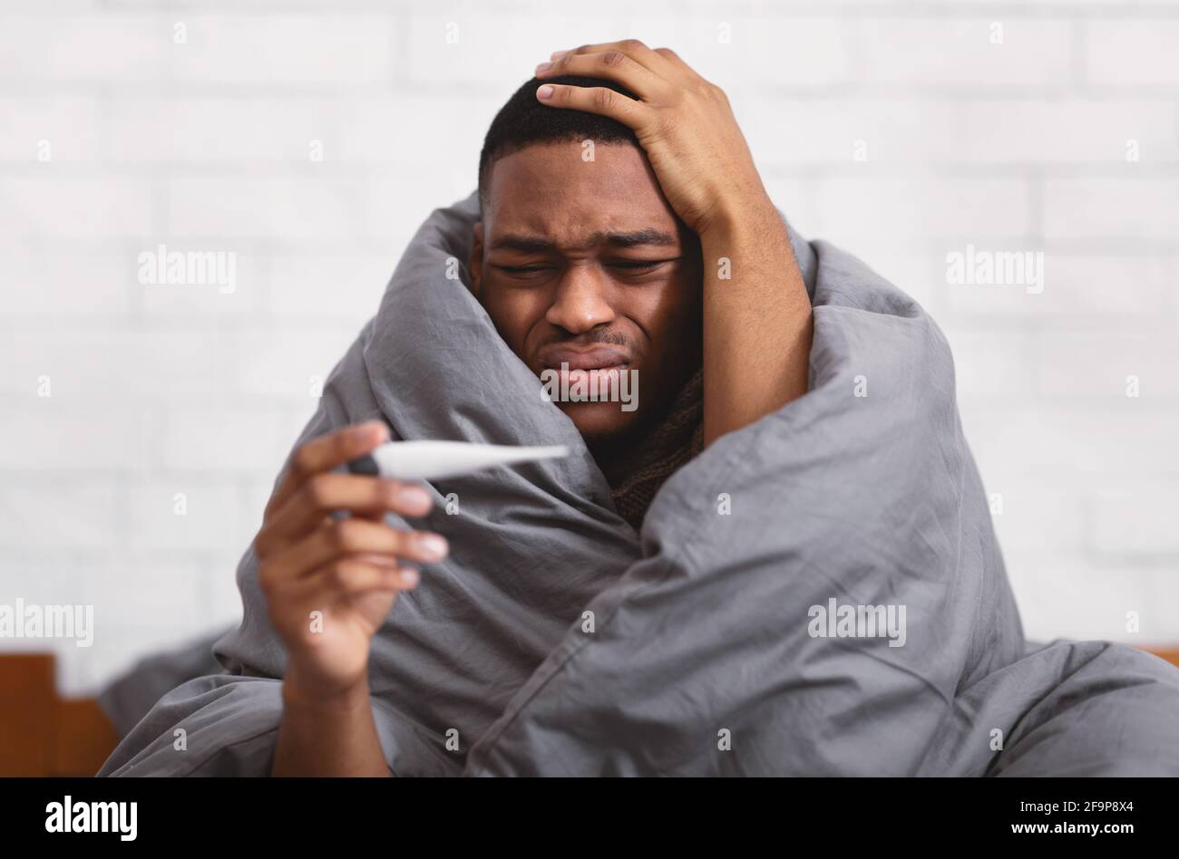 Sick African Man With Thermometer Having Fever Sitting At Home Stock ...