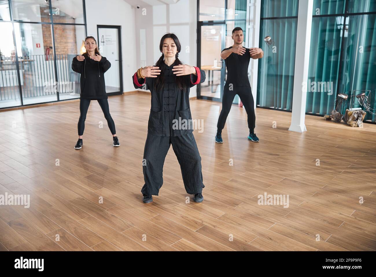 Two women and sportive man using tai chi form Stock Photo - Alamy