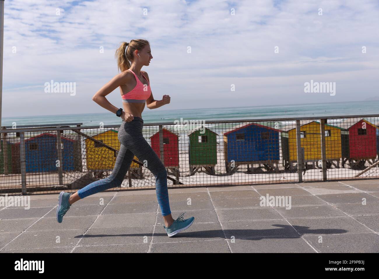 Caucasian woman exercising jogging on a promenade by the beach. healthy ...