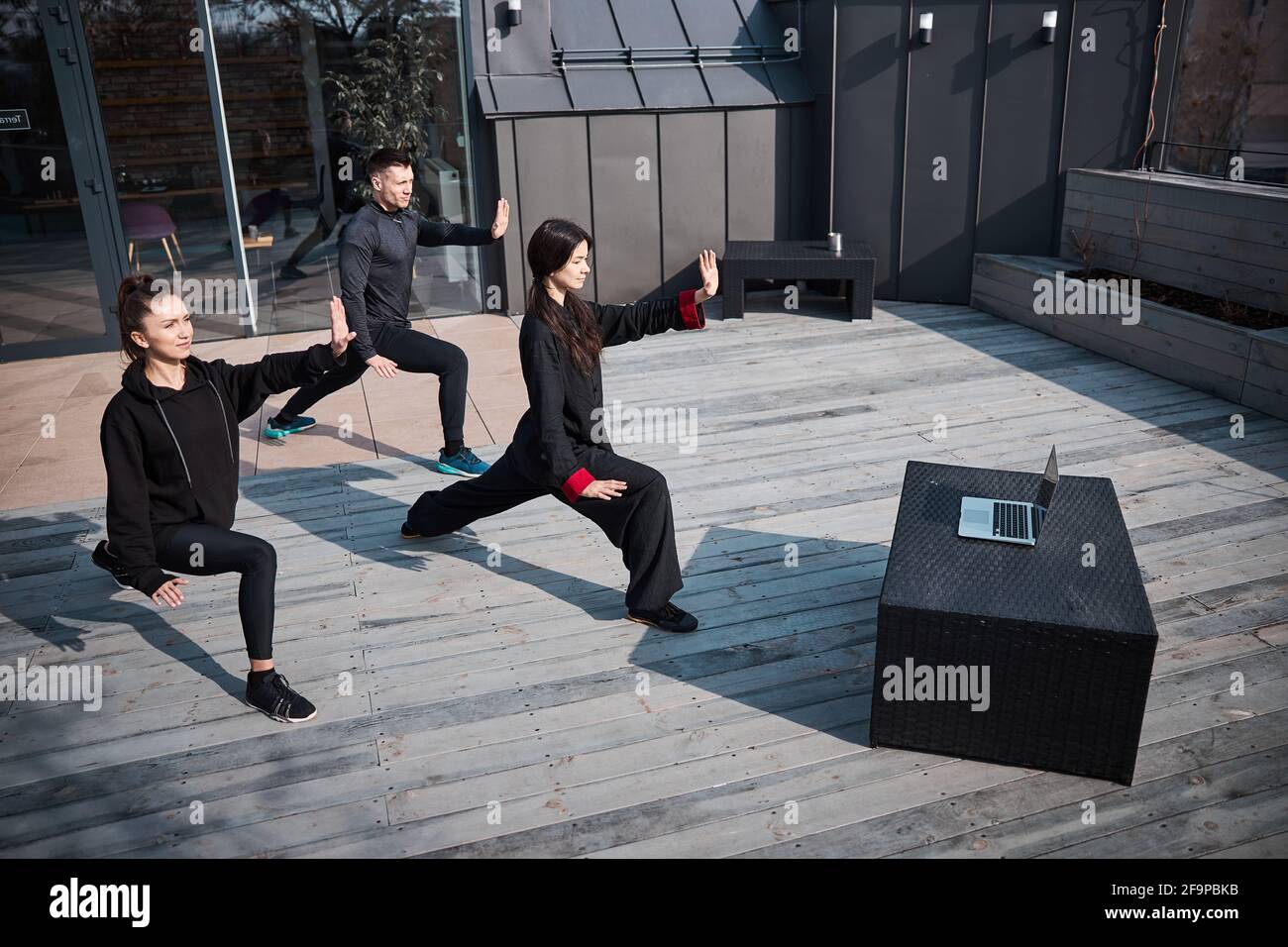 Outdoors training of brush knee push by three people Stock Photo - Alamy