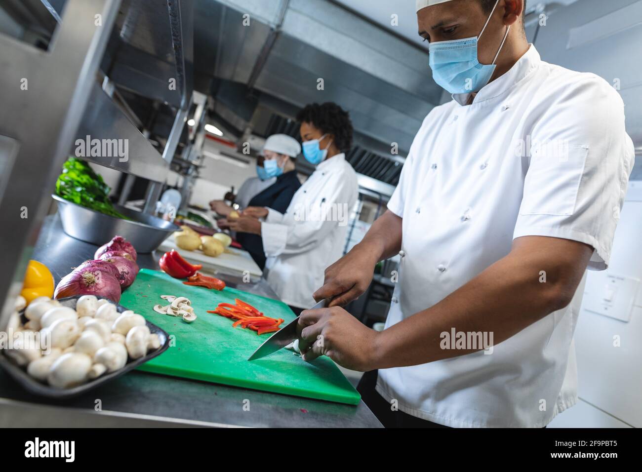 Diverce race male and female professional chefs preparing vegetables ...
