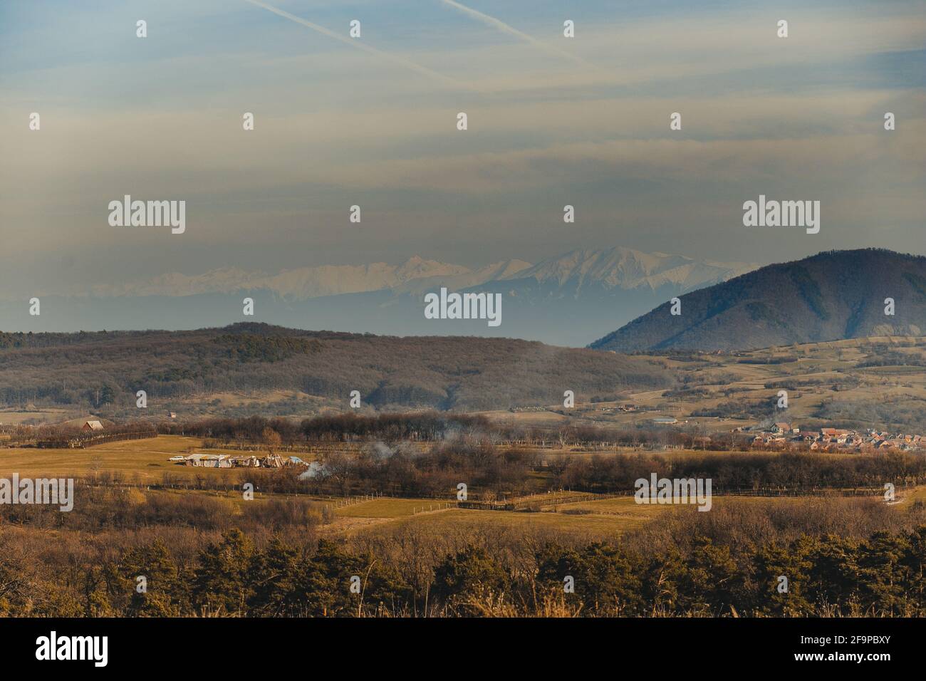 Scenic view of a vast field near a village with a mountainous landscape ...