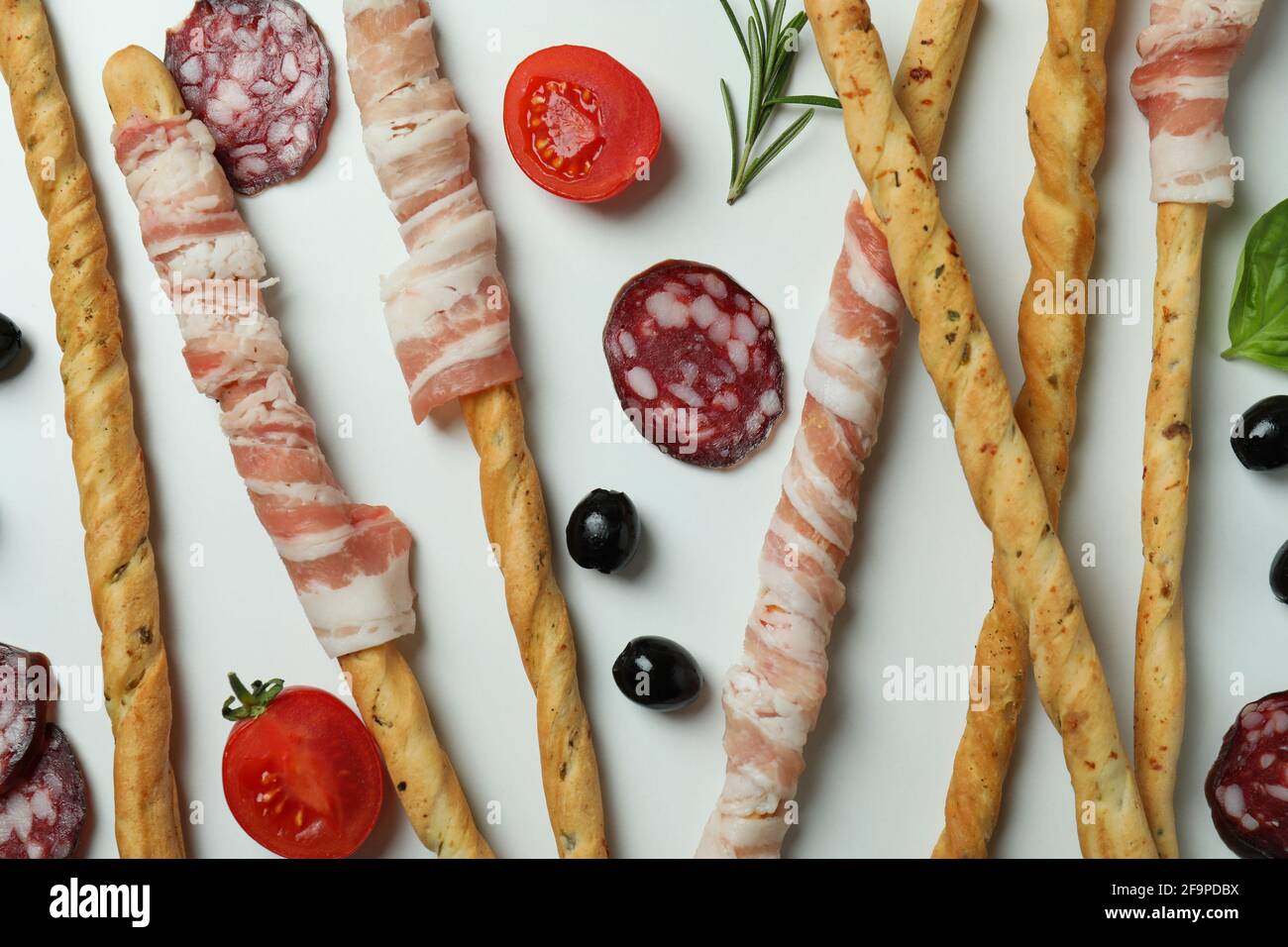 Grissini sticks with bacon and snacks on white background Stock Photo ...