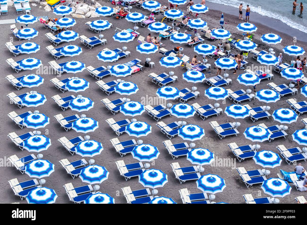 aerial view of blue and white parasols situated on a beach in italy ...