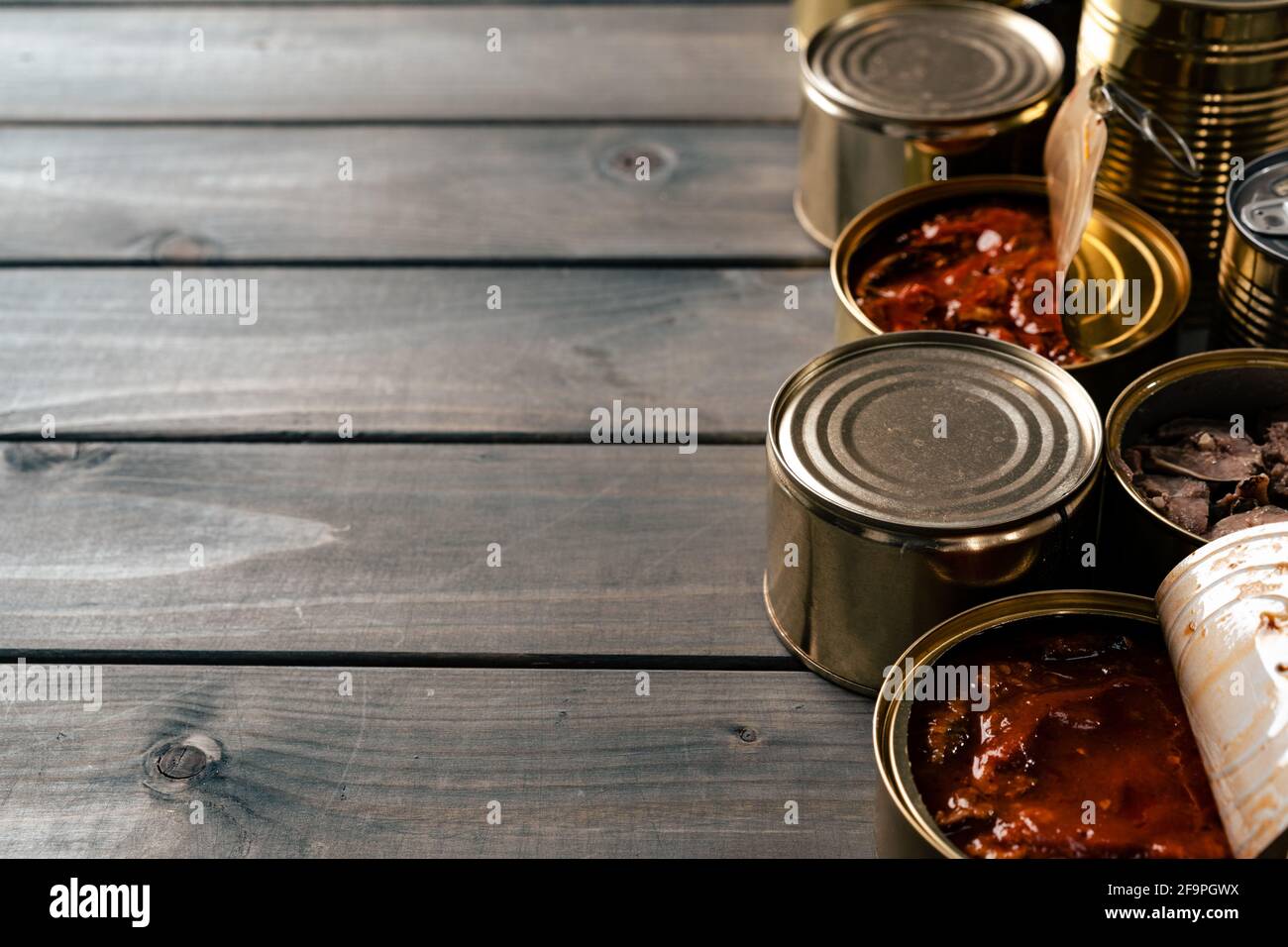 Many cans with conserved fish on wooden table Stock Photo - Alamy