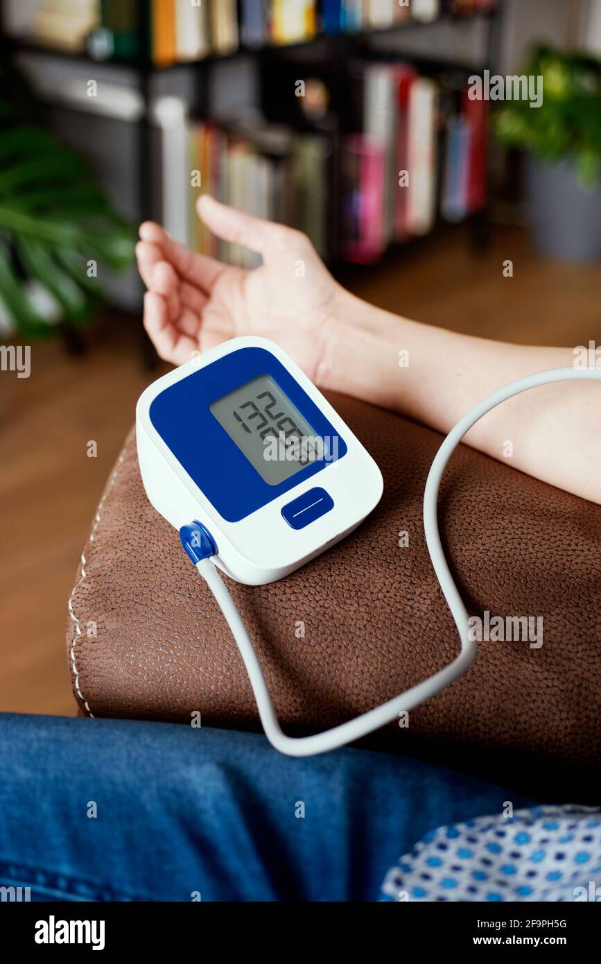 closeup of a caucasian man, sitting comfortably in a sofa, measuring ...