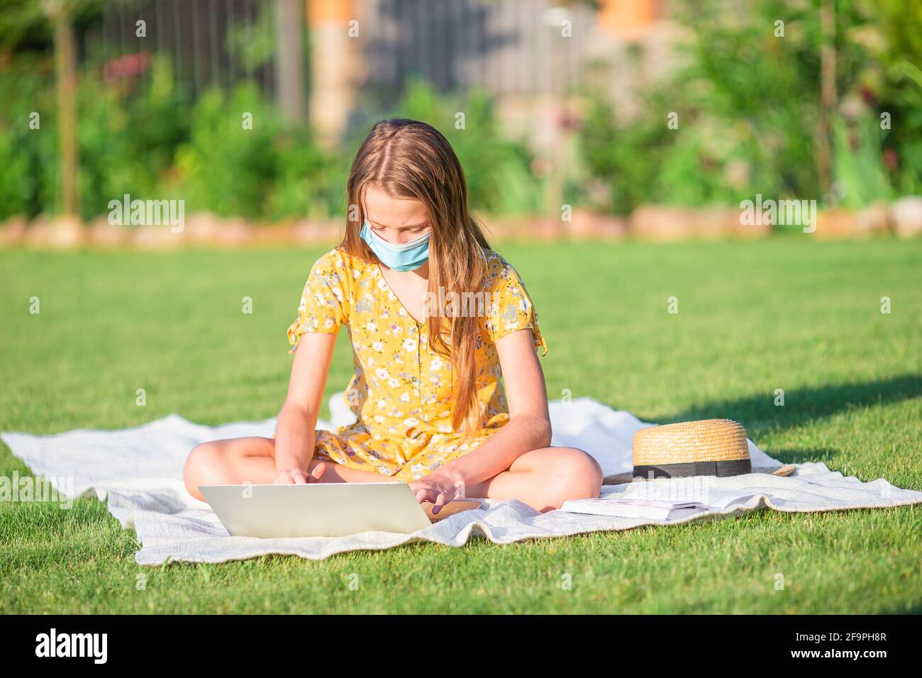 Little girl outdoors in the park with computer Stock Photo - Alamy