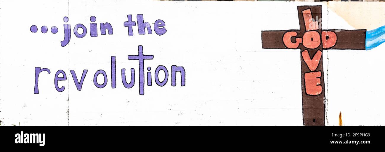 Words on a wall saying join the revolution and love god Stock Photo - Alamy