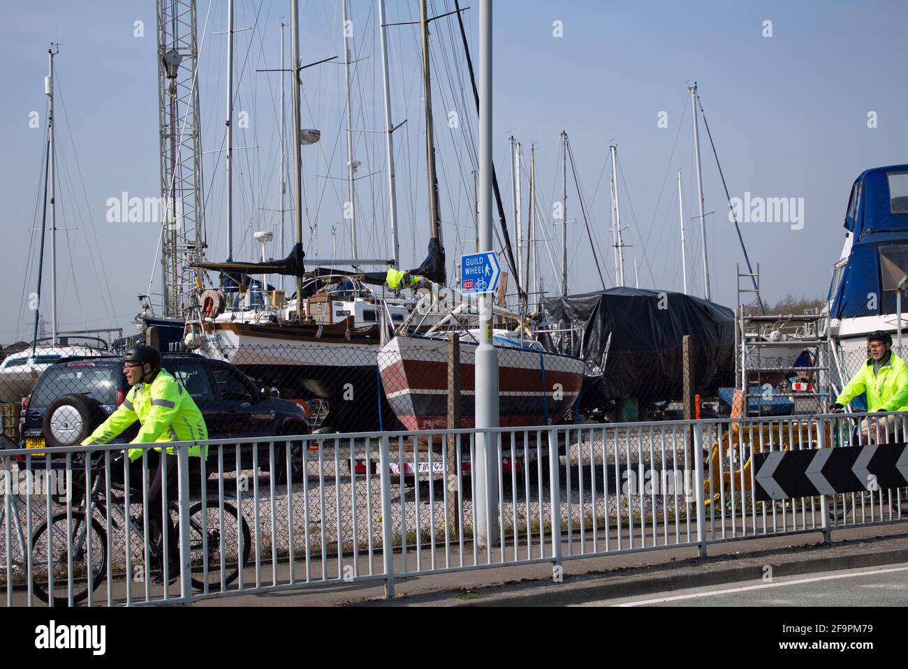 Cycling past the boatyard Stock Photo - Alamy