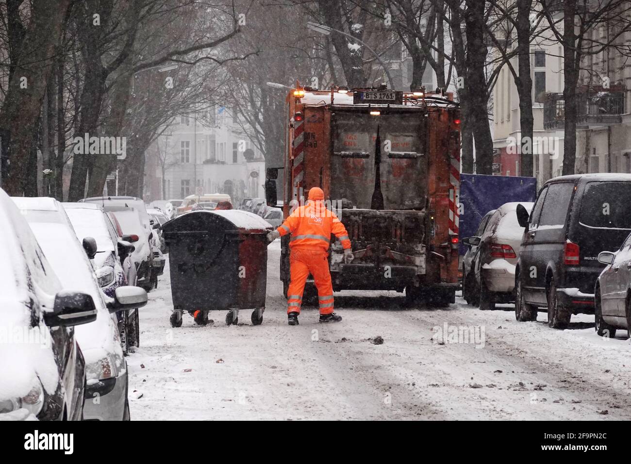 08.02.2021, Berlin, , Germany - BSR employee pushing a full residual ...