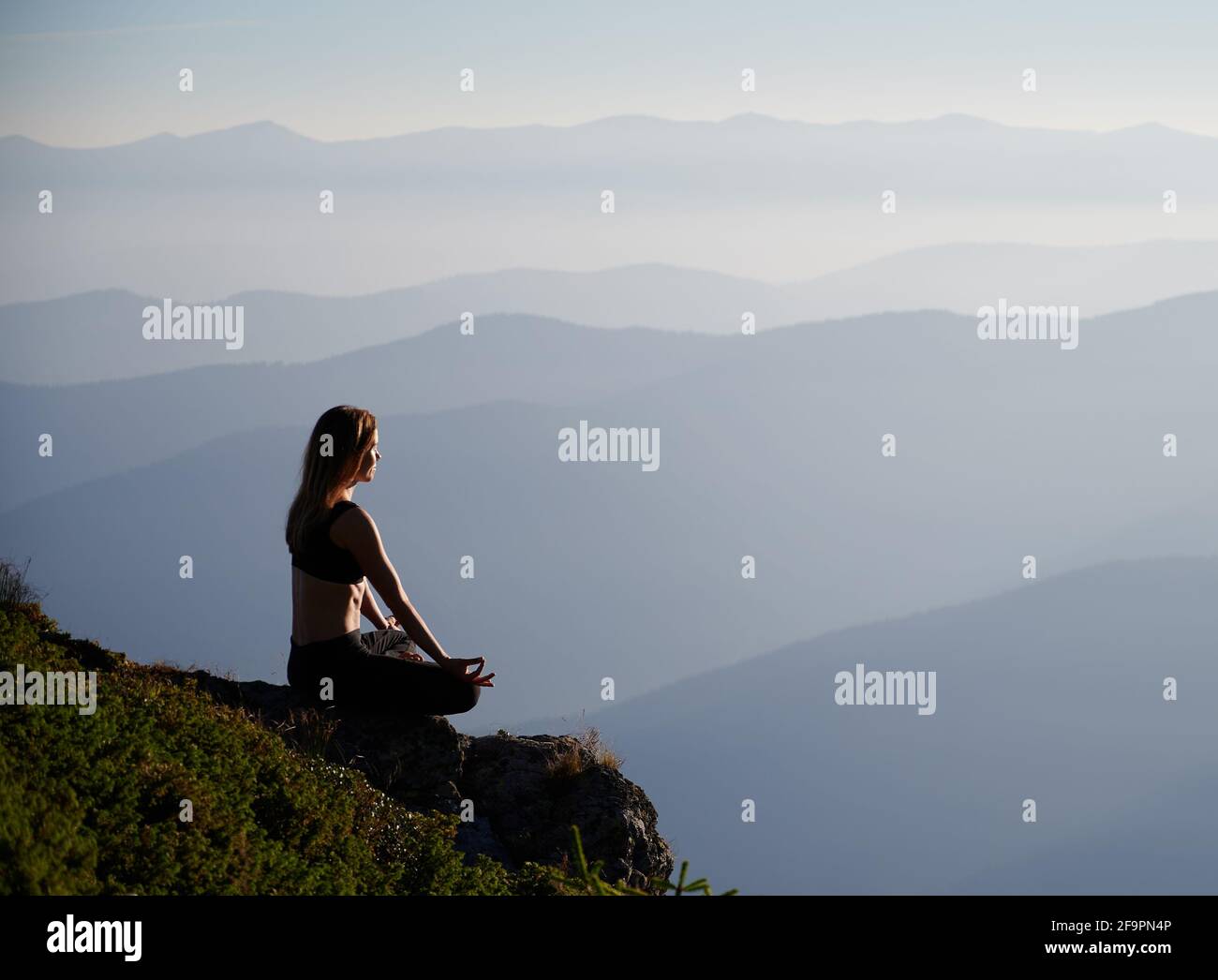 Side view of young woman enjoying nature and beautiful landscape ...