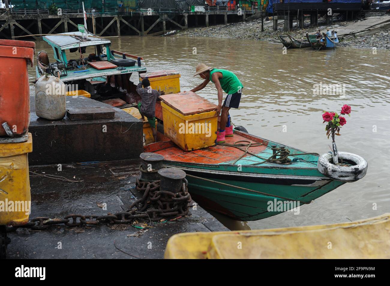 28.06.2014, Yangon, , Myanmar - Workers unload cold boxes from a boat ...