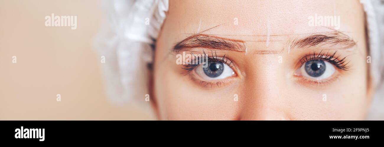 Cosmetolog beauty master making marks before the permanent makeup ...