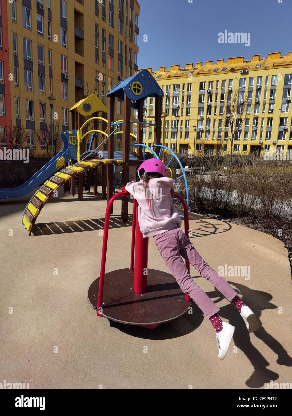 A girl of eight years in crash helmet riding on carousel. Child on ...