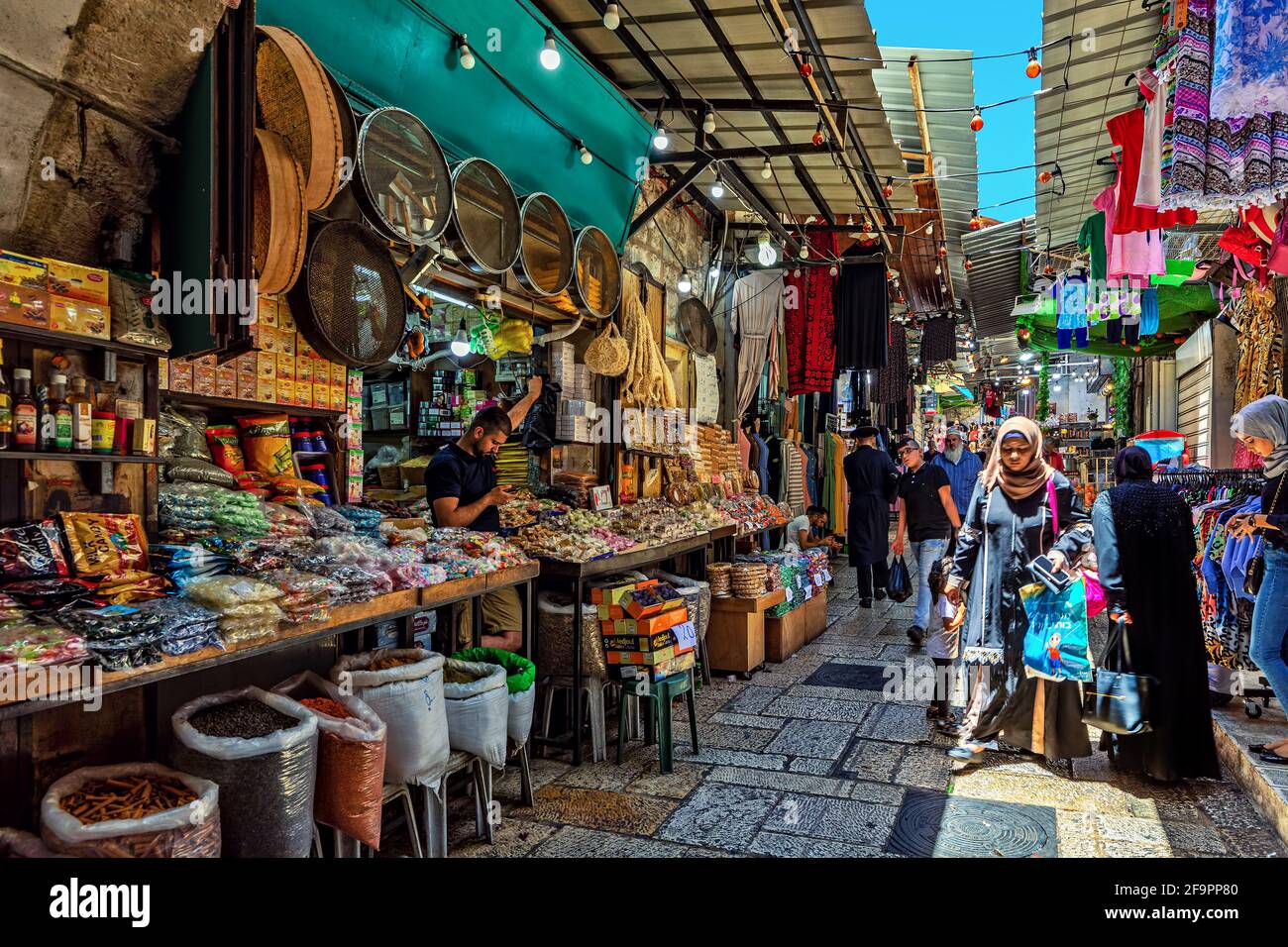 People walking on narrow street with typical shops on famous bazaar ...
