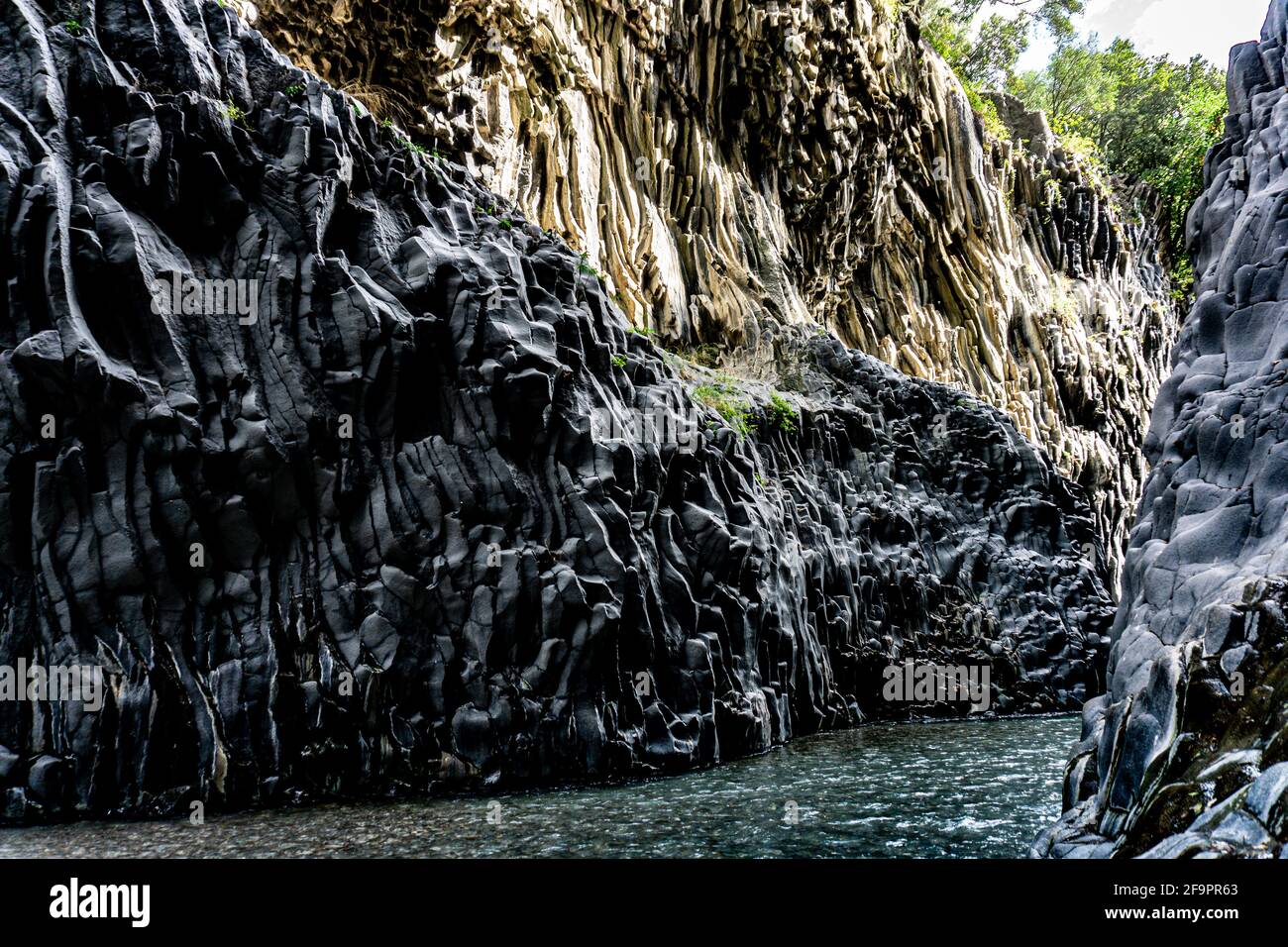 Alcantara river gorge flowing among basalt geological formations in ...