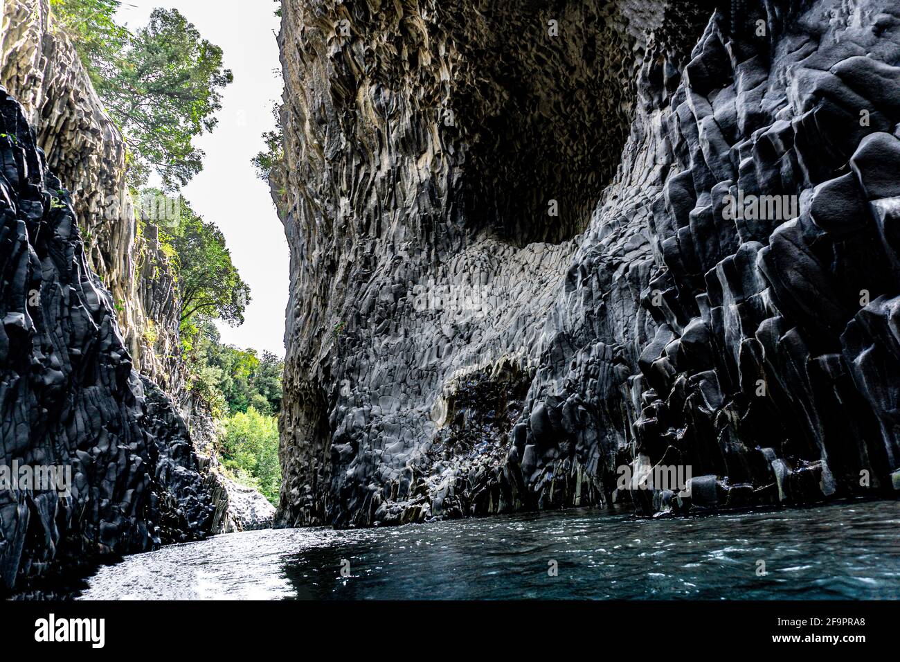Alcantara river gorge flowing among basalt geological formations in ...