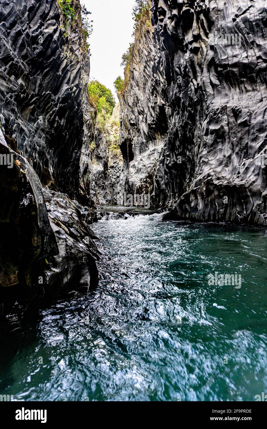 Alcantara river gorge flowing among basalt geological formations in ...