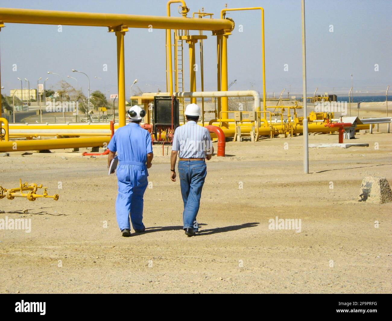 Two engineers inspect a new installation at an oil and gas facility in ...