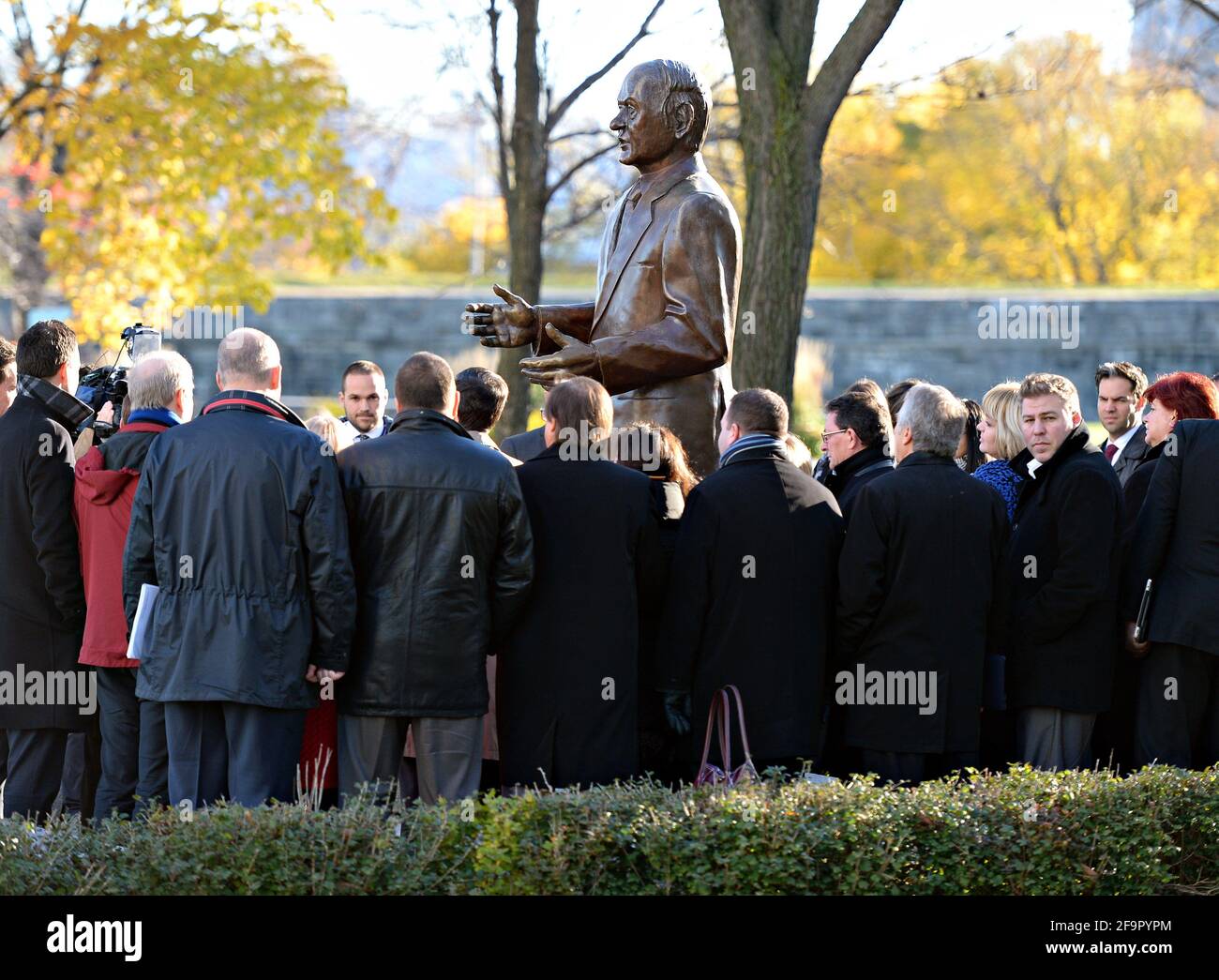 Members of the quebec parliament commune around the statue of René ...