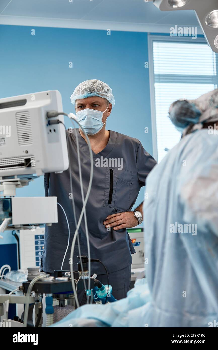 Anesthesiologist keeping track of vital functions of the body during ...