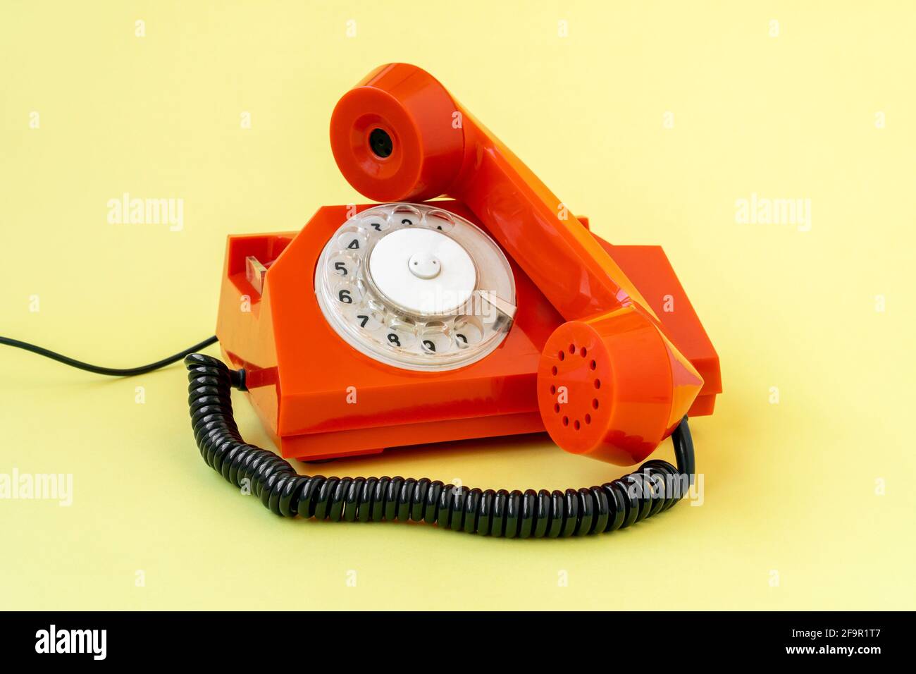 Retro orange telephone on yellow background. Communication concept ...