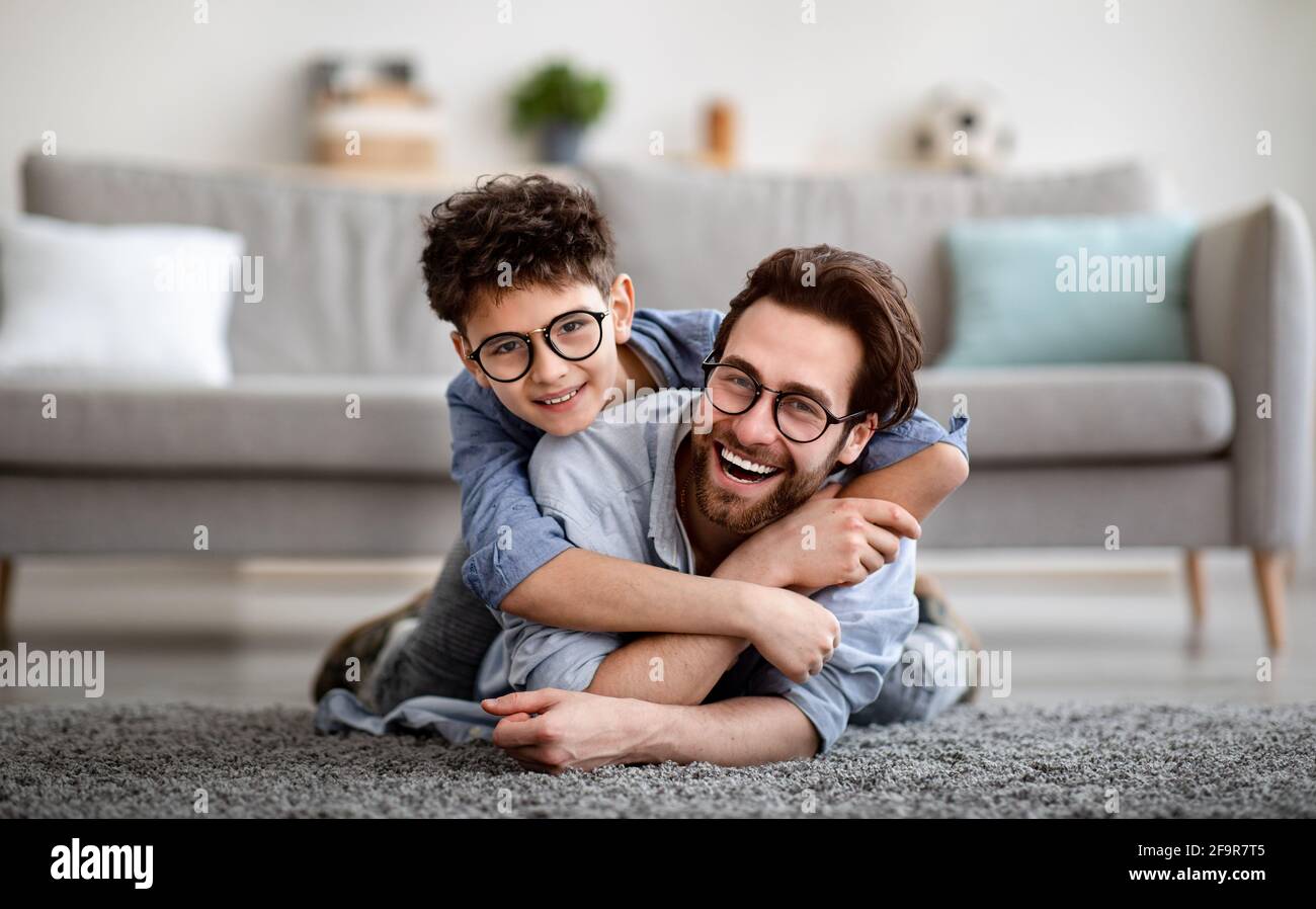 Parents and children being friends. Joyful father and son having fun ...