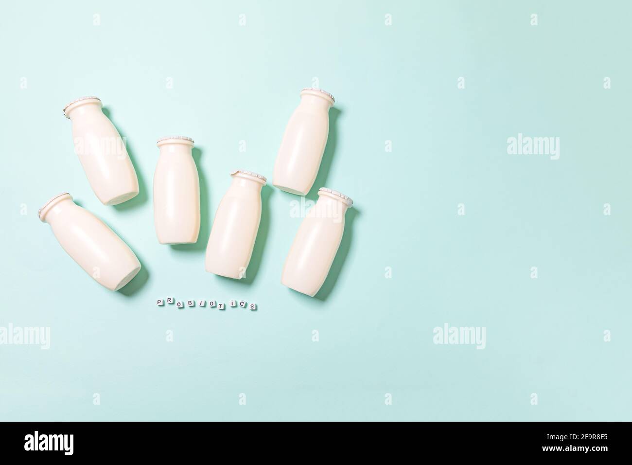 Small bottles with probiotics and prebiotics dairy drink on blue ...
