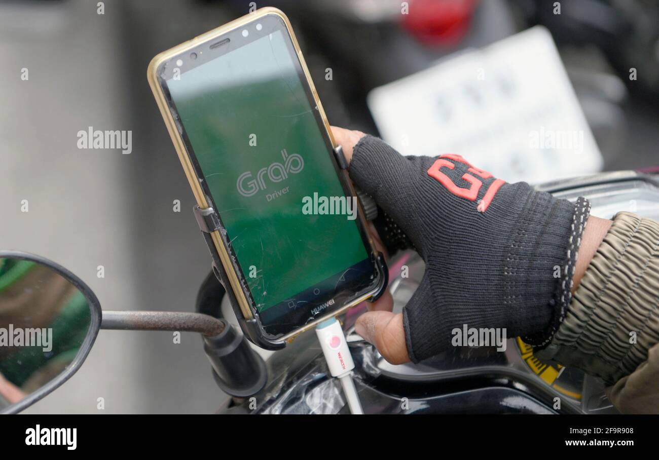A close up of a mobile phone and the Grab App.During the Covid-19 ...