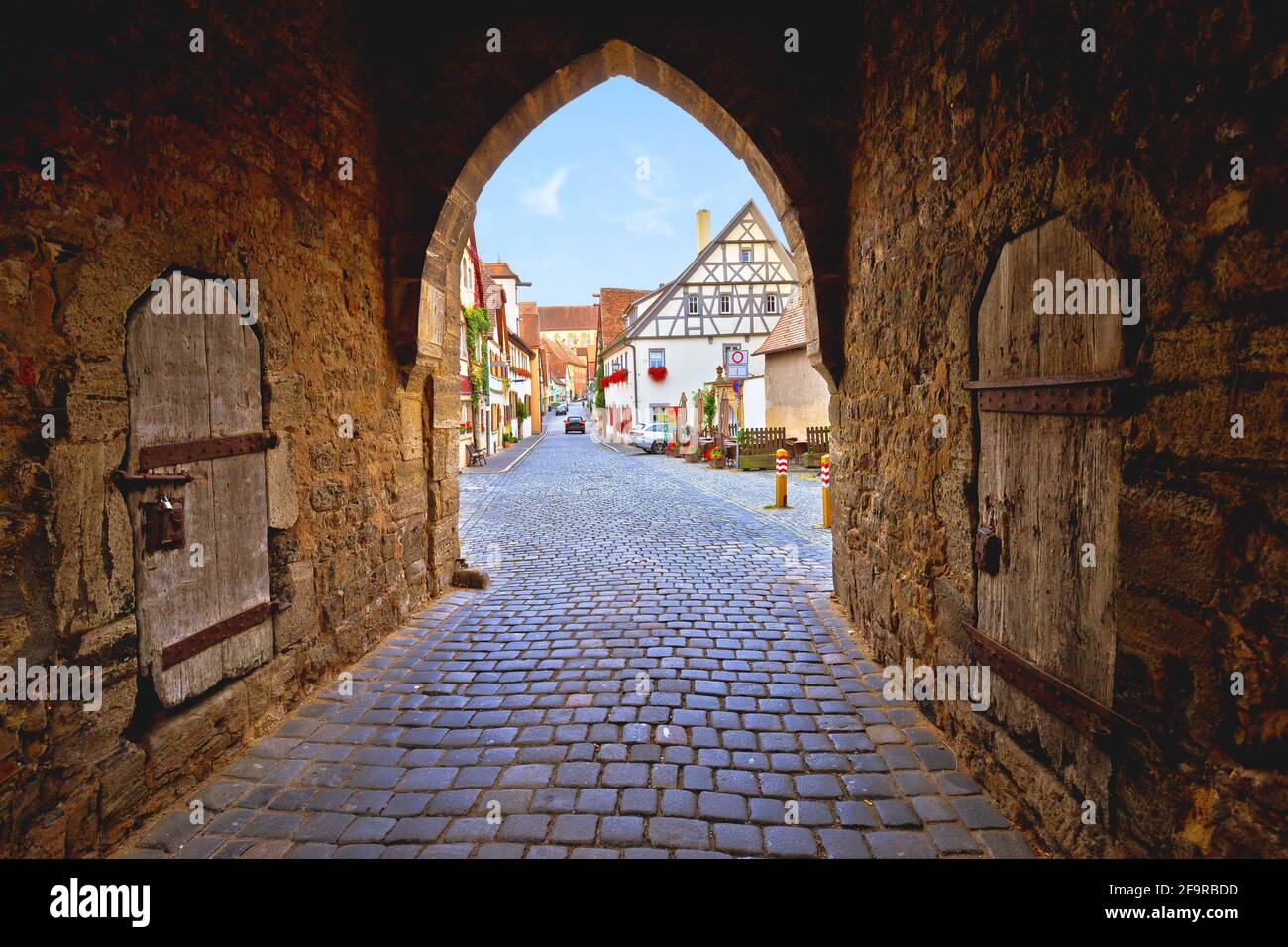 Idyllic German cobbled street. Tower gate passage and street ...