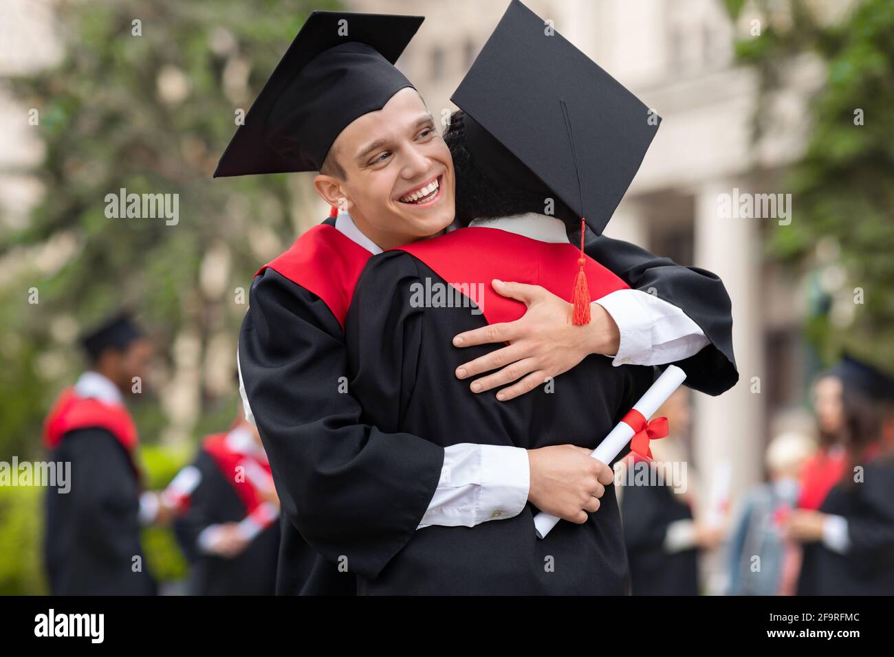 Happy guys students greeting each other with graduation Stock Photo - Alamy