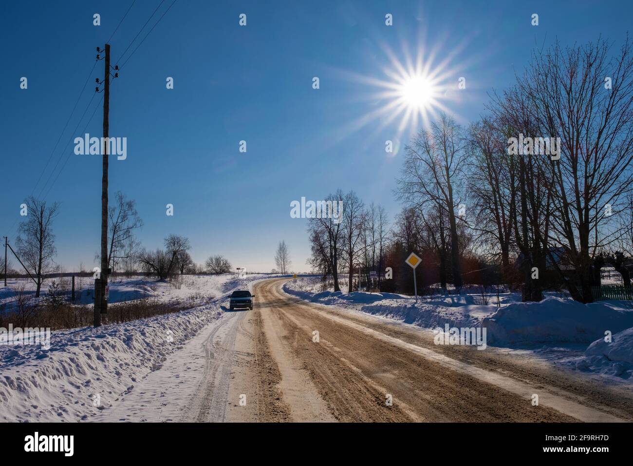 A sun disk with many rays on a blue sky background and a car road Stock ...