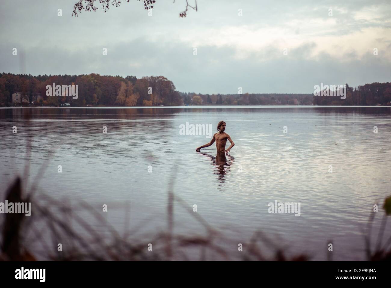 athletic healthy fit man stands in beautiful natural lake in germany ...