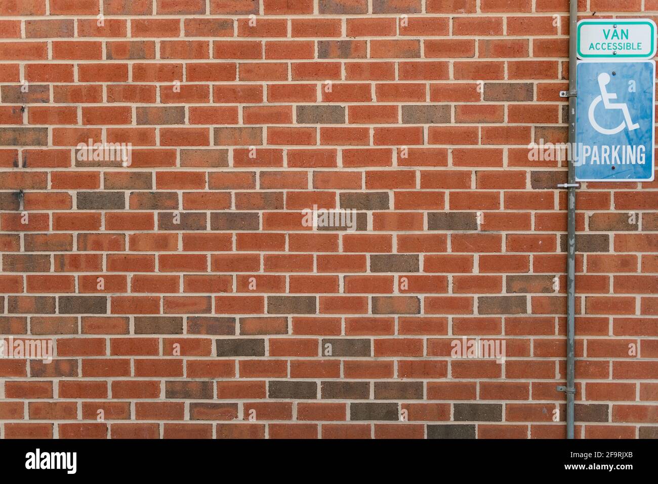 Brick wall with handicap parking sign Stock Photo - Alamy