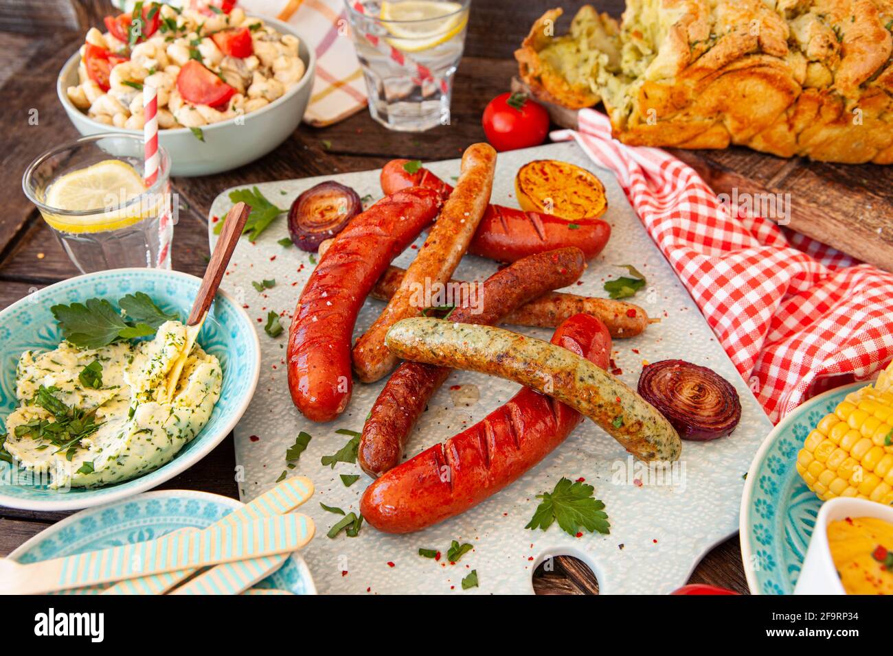BBQ with grilled sausages, pasta salad and homemade bread Stock Photo ...