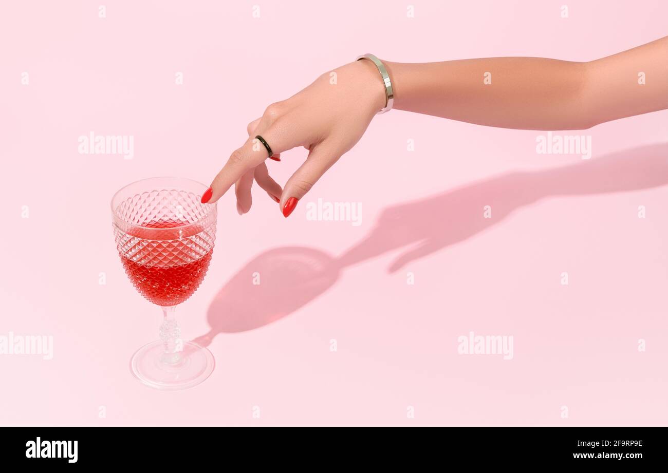 Womans hand touch glass on pink background. Manicure design trends ...