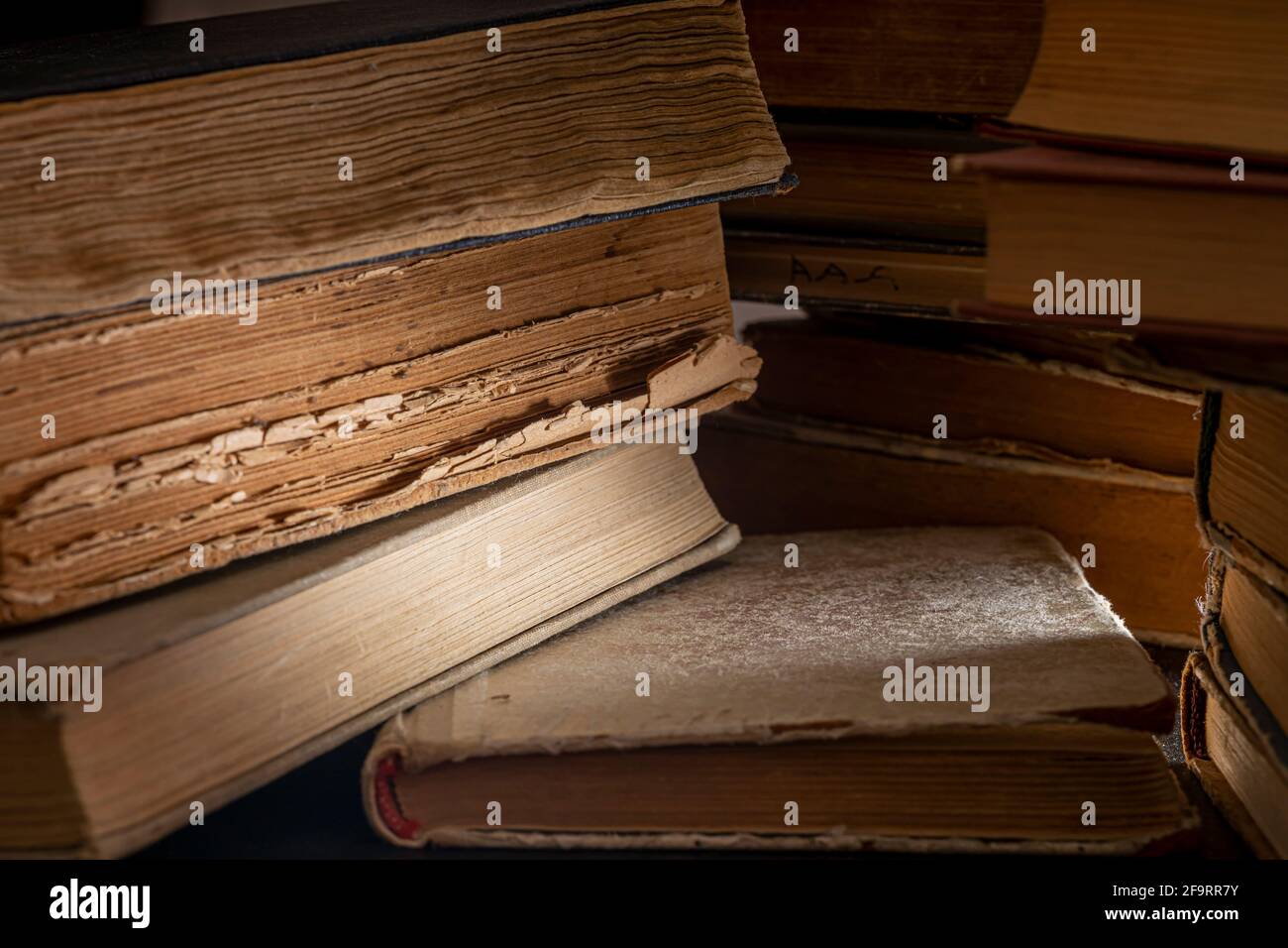 Stacks of old multi-format books with scuffs. Low depth of field ...