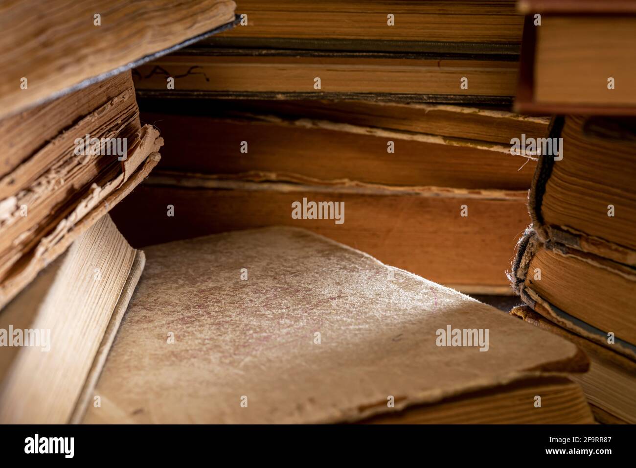 Stacks of old multi-format books with scuffs. Low depth of field ...