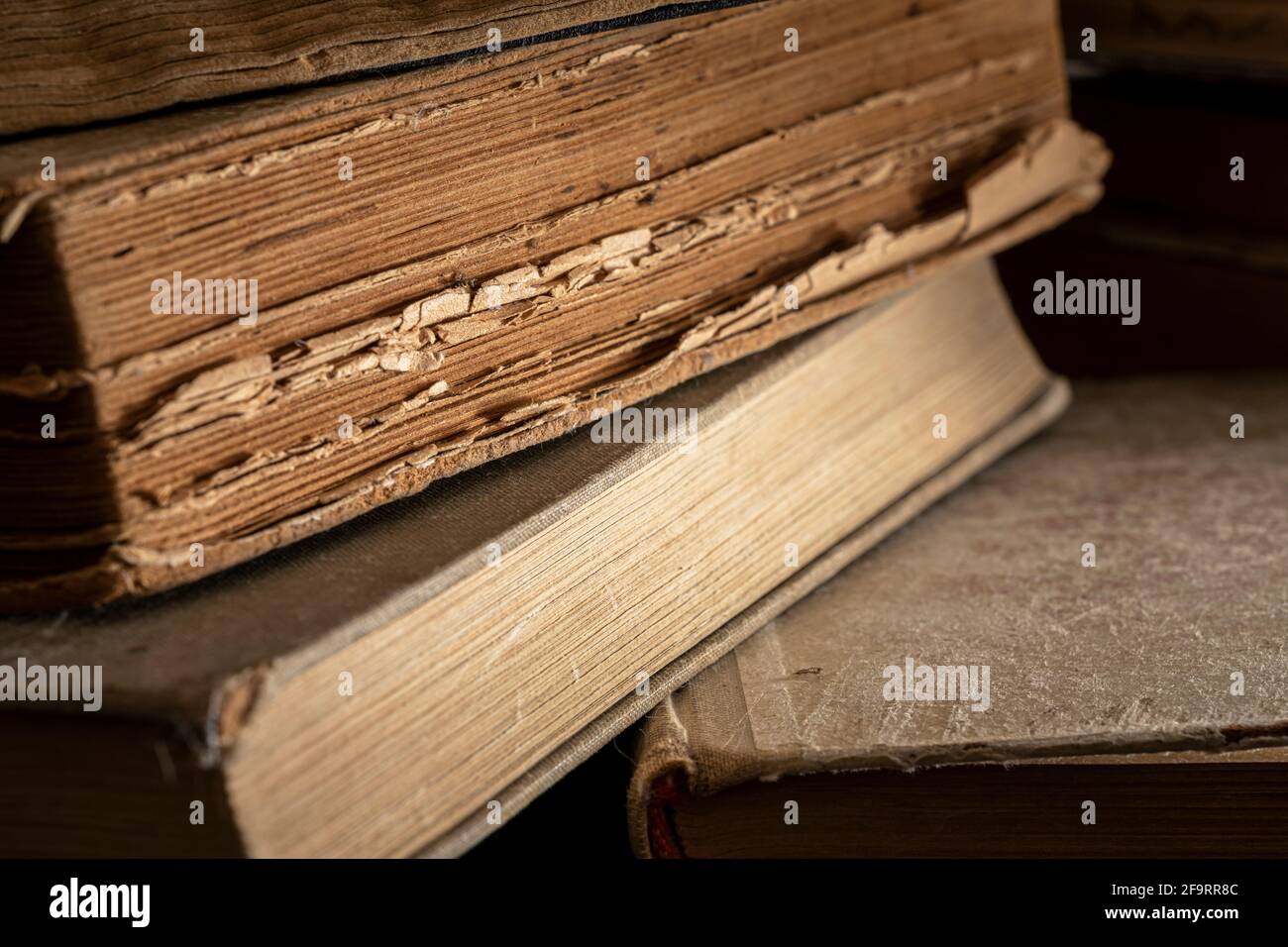 Stacks of old multi-format books with scuffs. Low depth of field ...