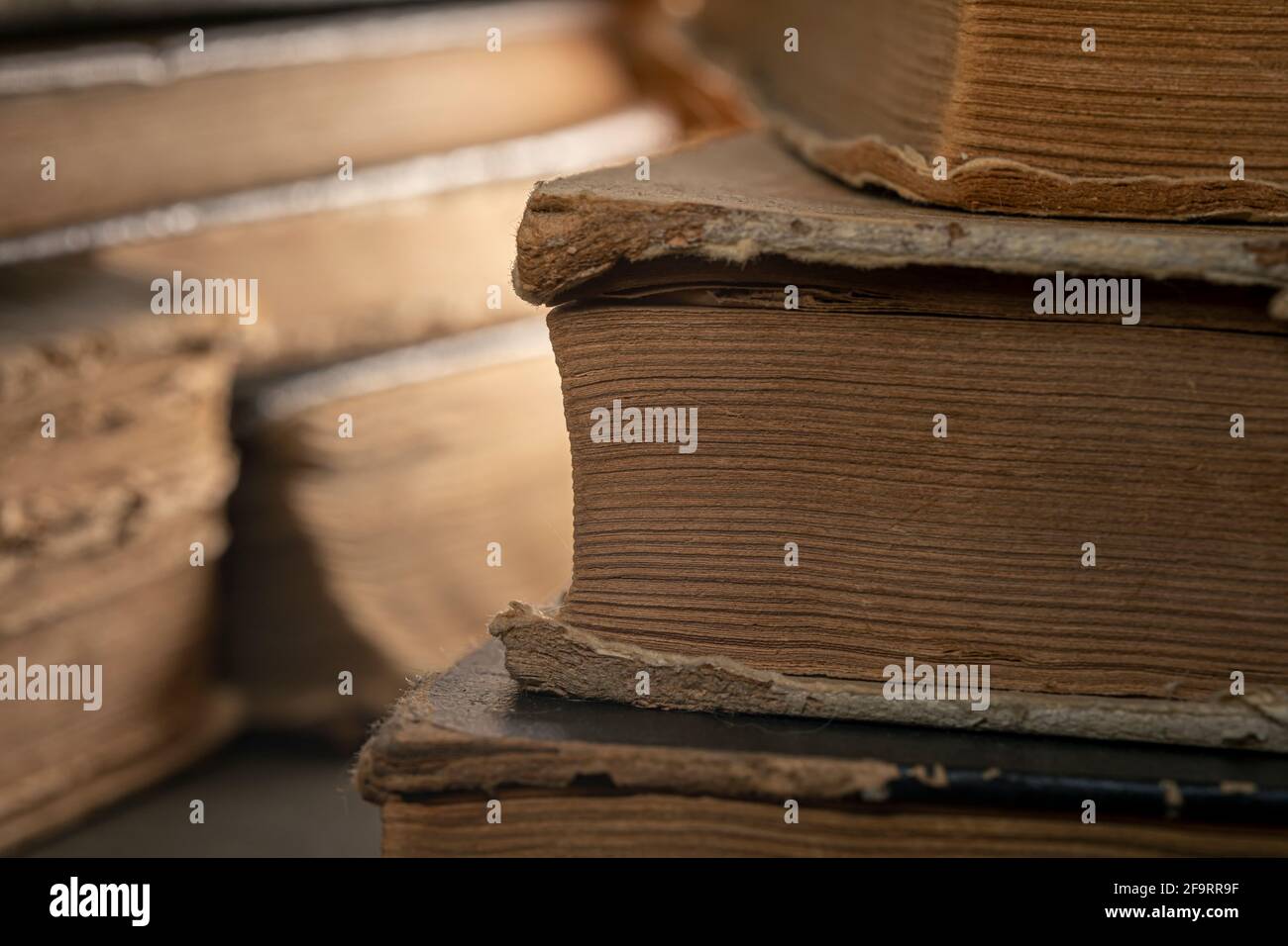 Stacks of old multi-format books with scuffs. Low depth of field ...