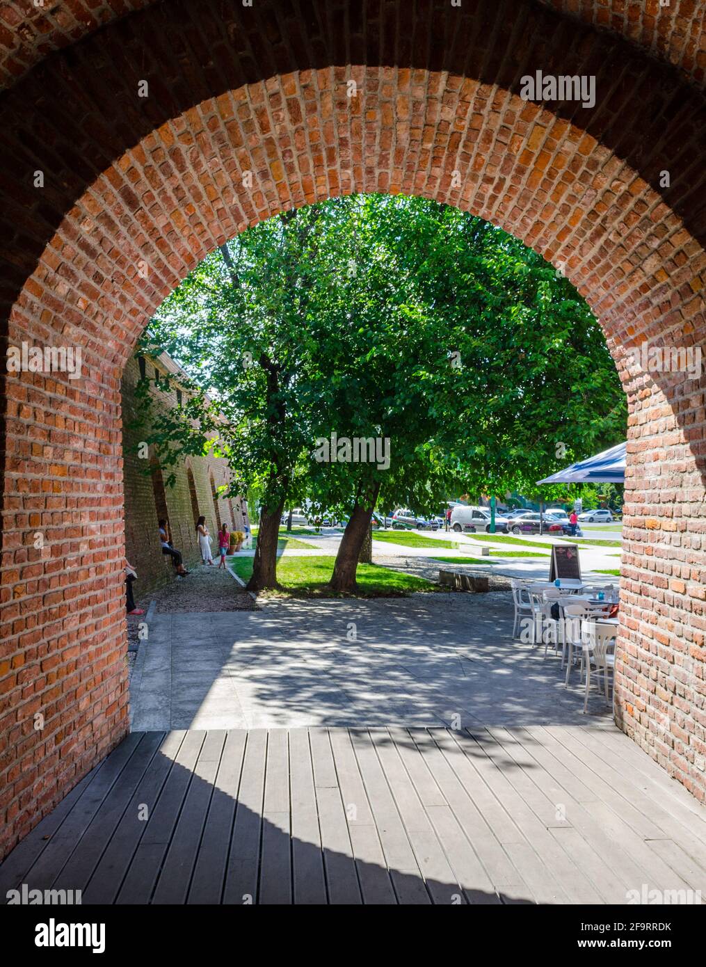 red brick arc with a green tree behind it Stock Photo - Alamy