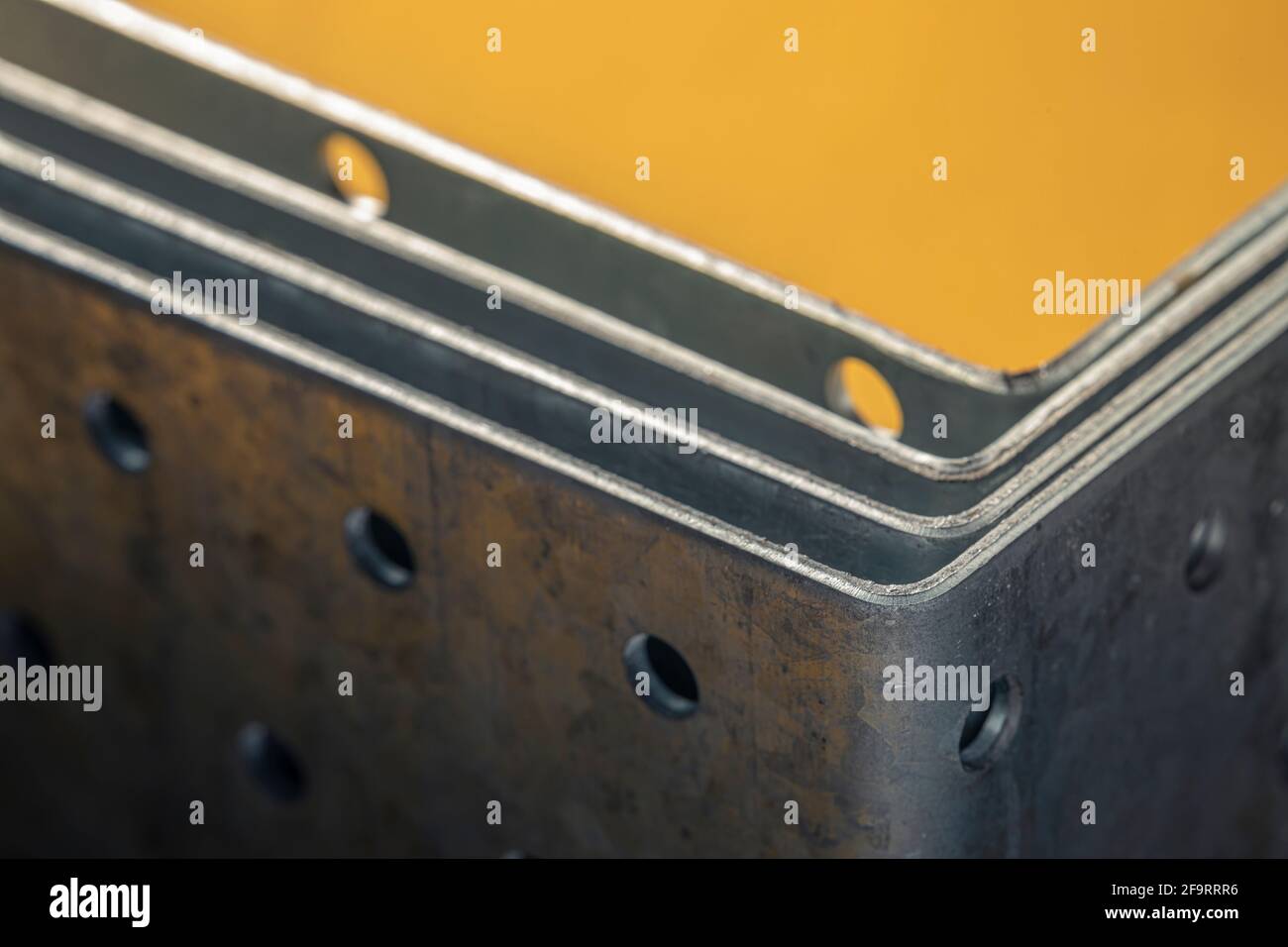 Stack of construction perforated steel angle brackets close up. Low ...