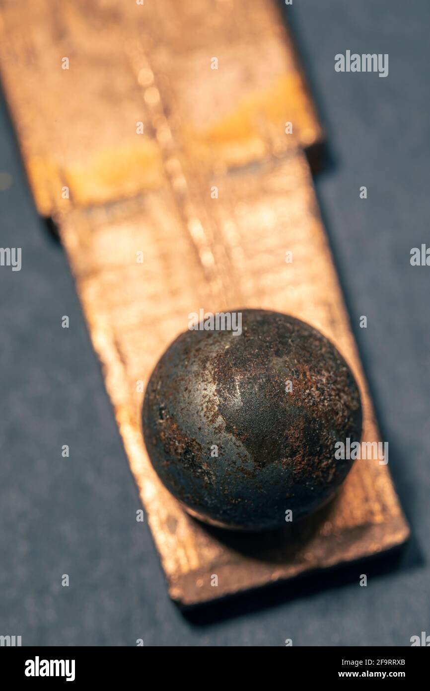 Closeup of a rusty ball bearing on a copper plate. Low depth of field ...
