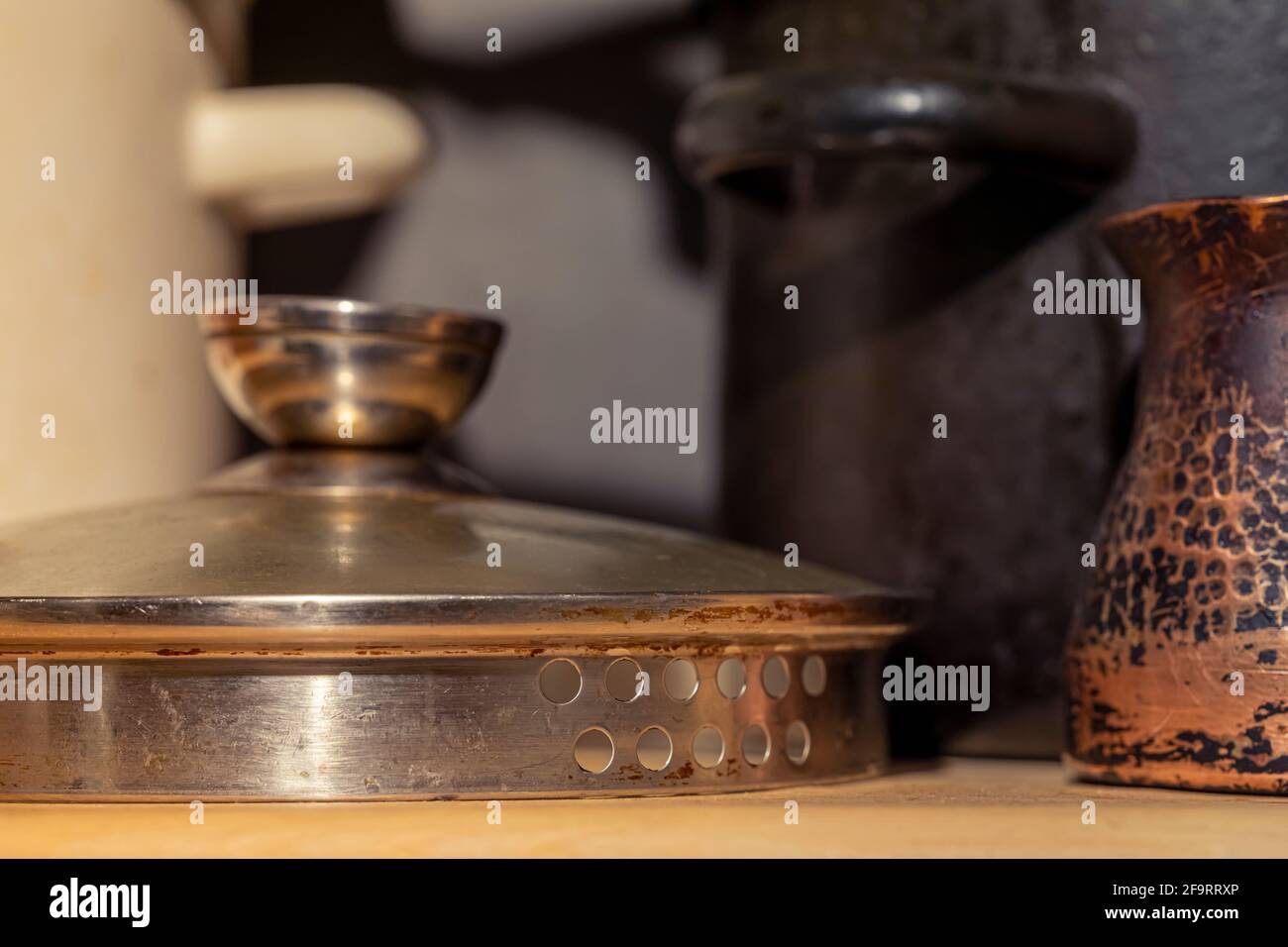 Kitchen shelf with kitchen utensils. Pots, pot lid and copper coffee ...