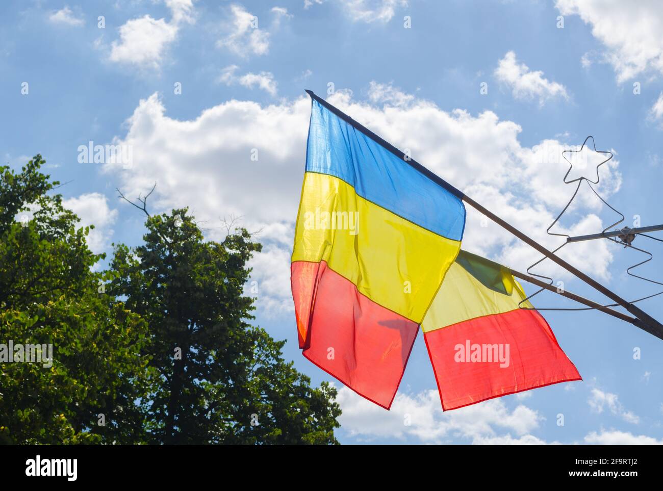 romanian flag is waving in wind with a tree behind it Stock Photo - Alamy
