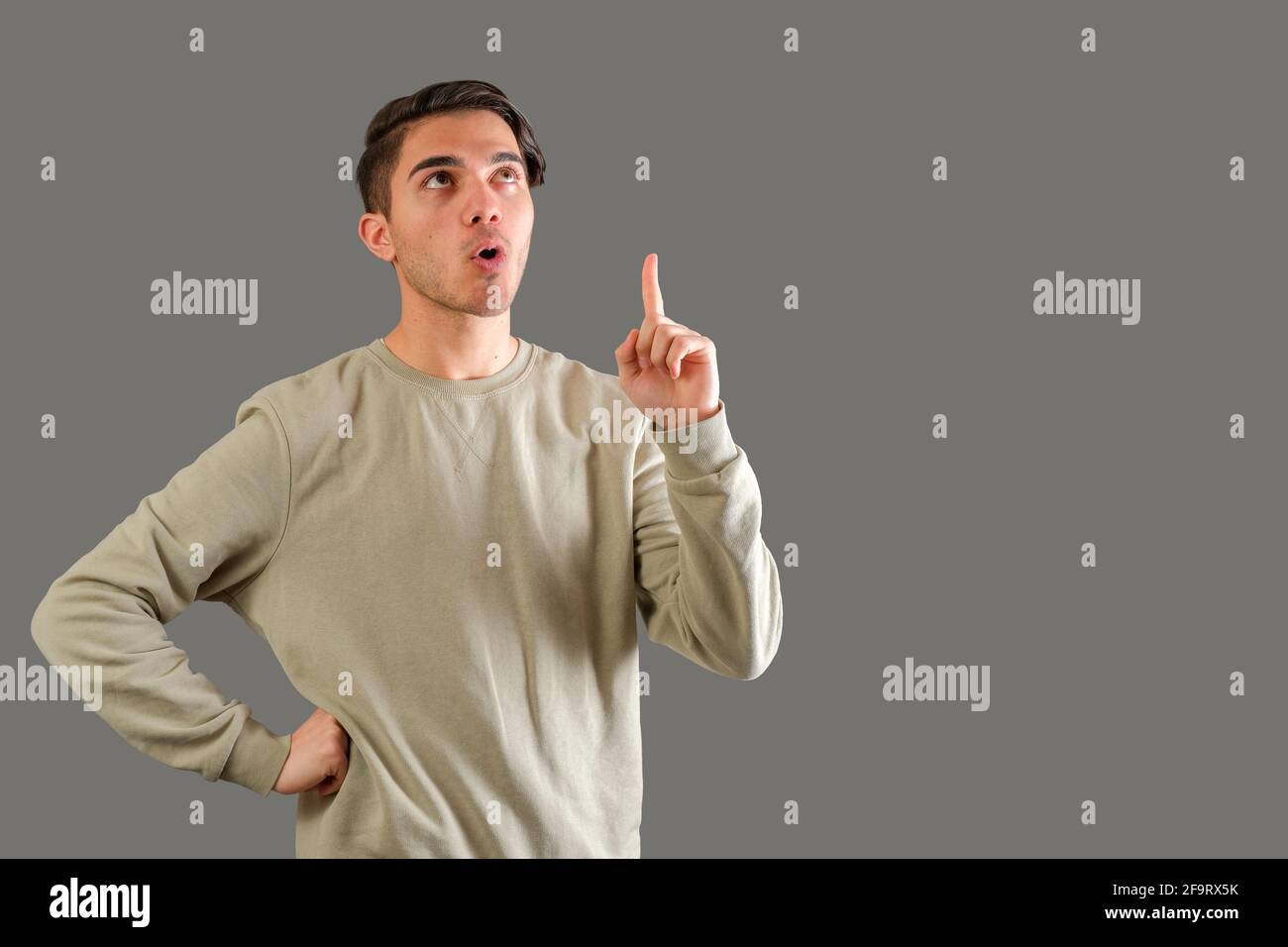 man pointing finger up isolated on gray background Stock Photo - Alamy